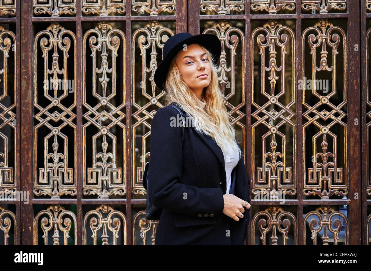 Unrecognizable female smoker with long brown hair in stylish black ...
