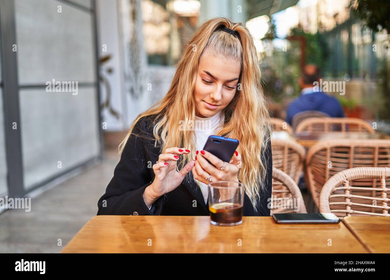 Positive blond Woman wearing casual clothes sending a text message on ...