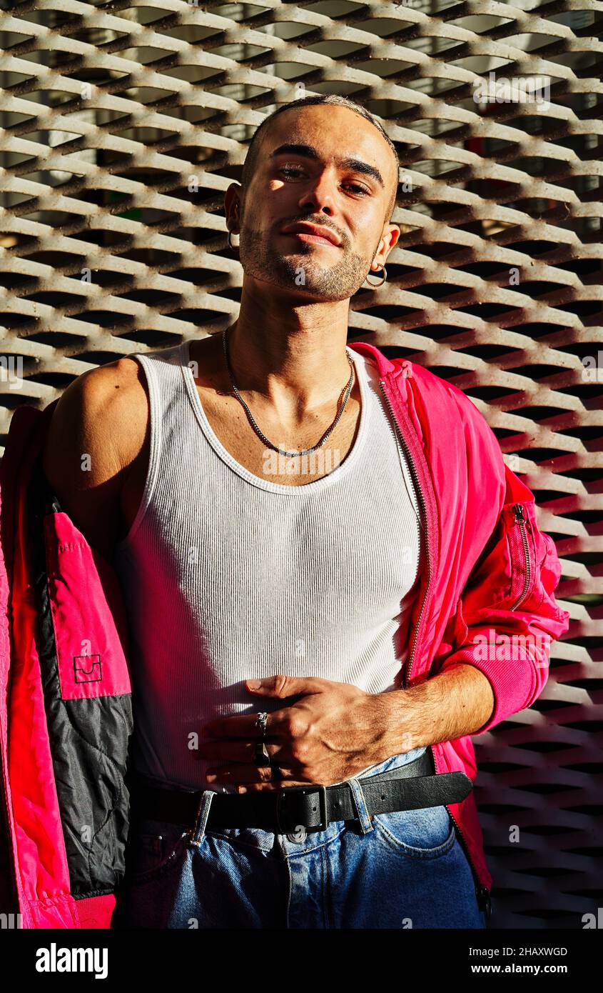 Confident eccentric male with dyed hair wearing stylish outfit standing ...