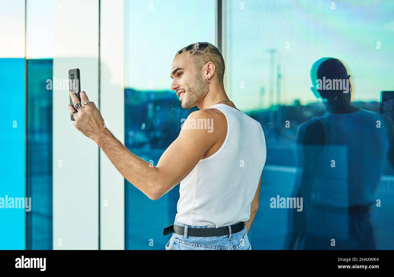 Back view of positive young male with stylish eccentric appearance ...