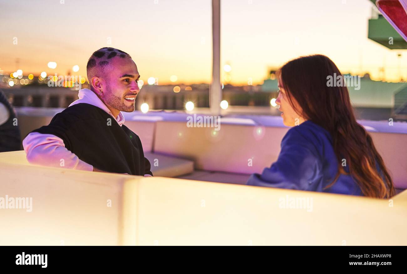 Side view of positive eccentric stylish male chatting with female ...