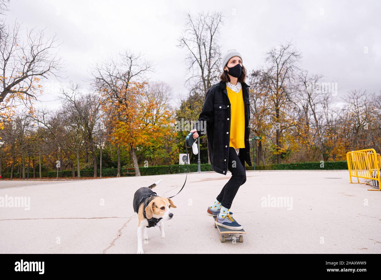 Full body of young cheerful female skating on skateboard on asphalt ...