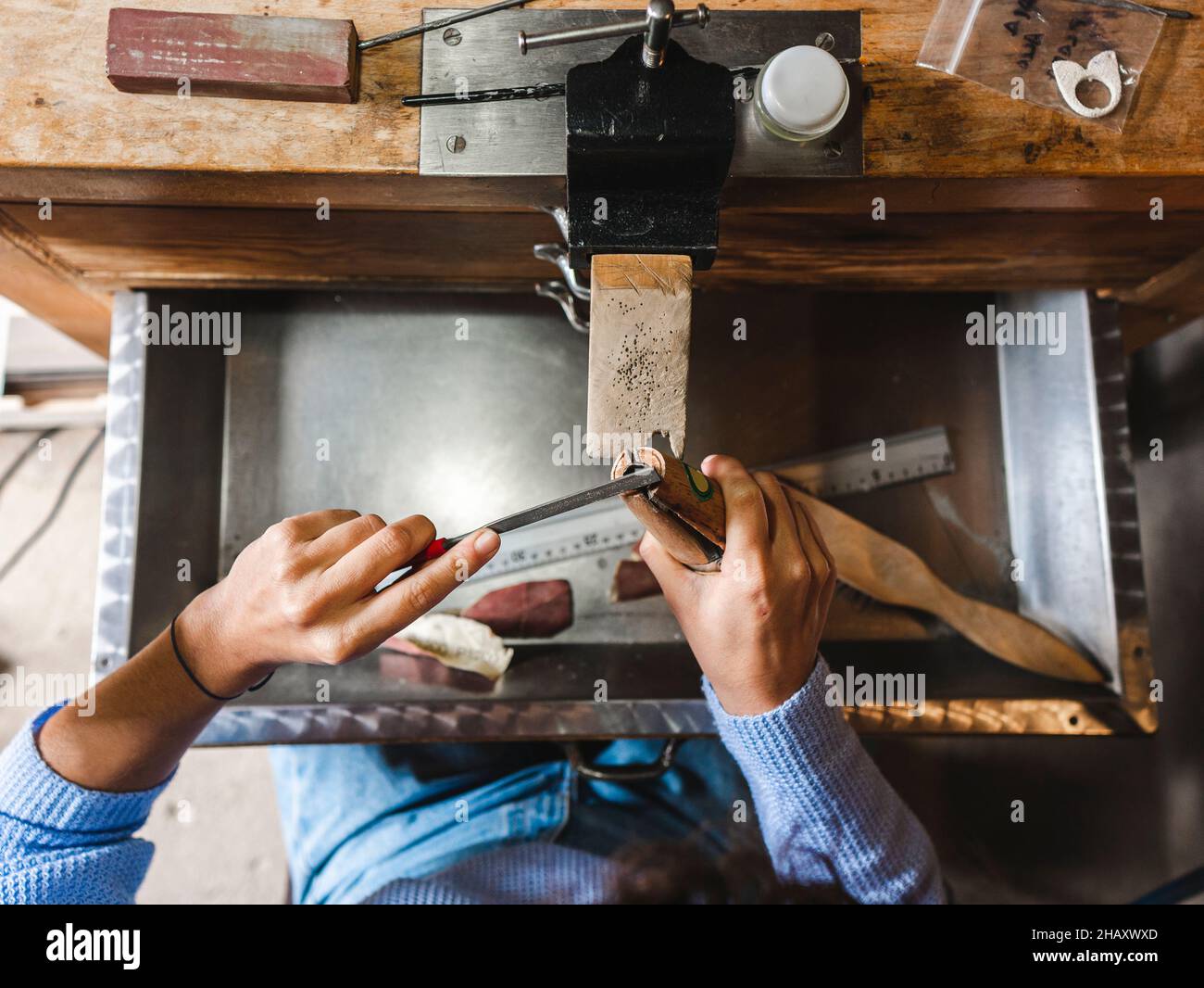 Side view of cropped unrecognizable female goldsmith using polishing ...