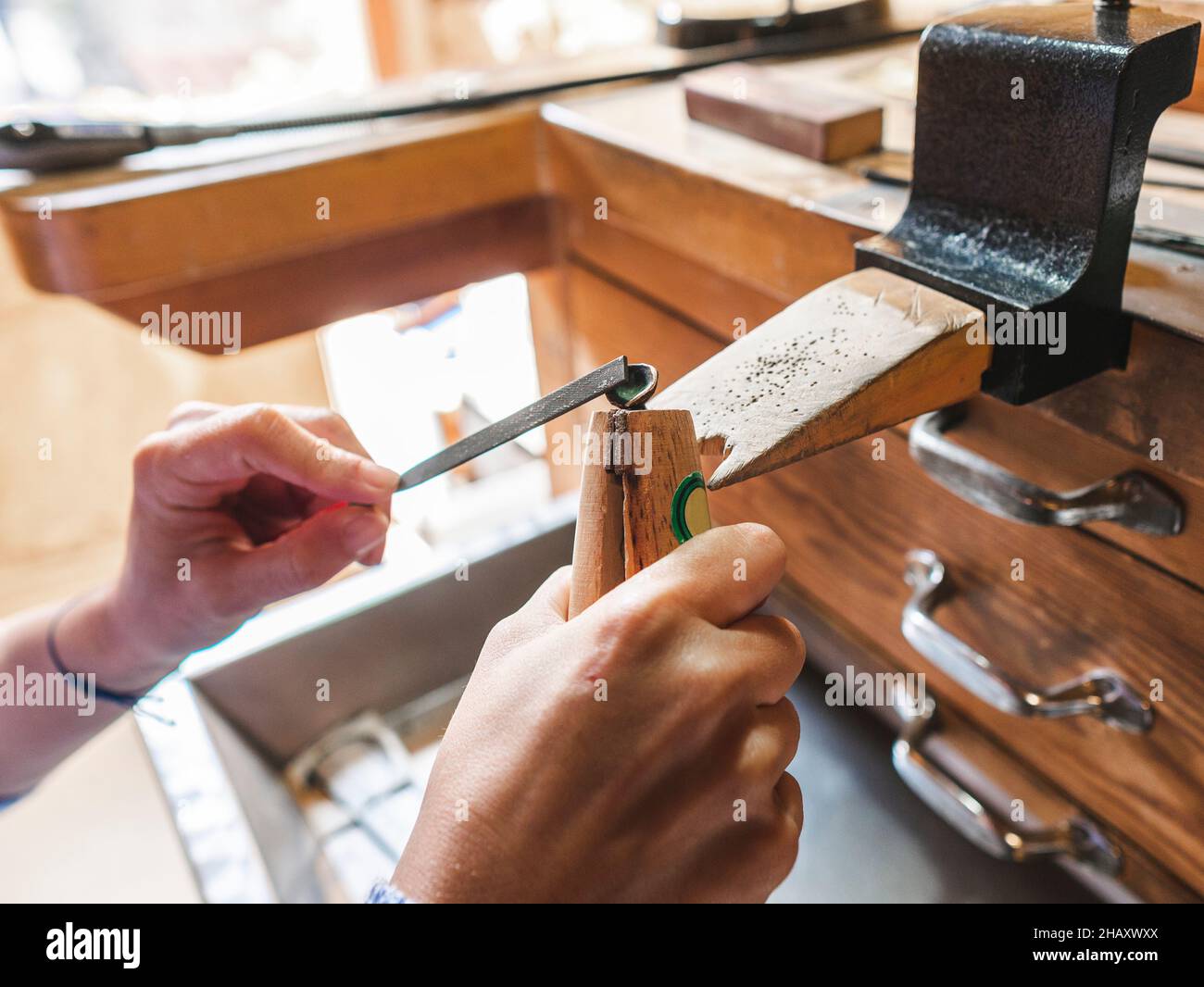 Side view of cropped unrecognizable female goldsmith using polishing ...