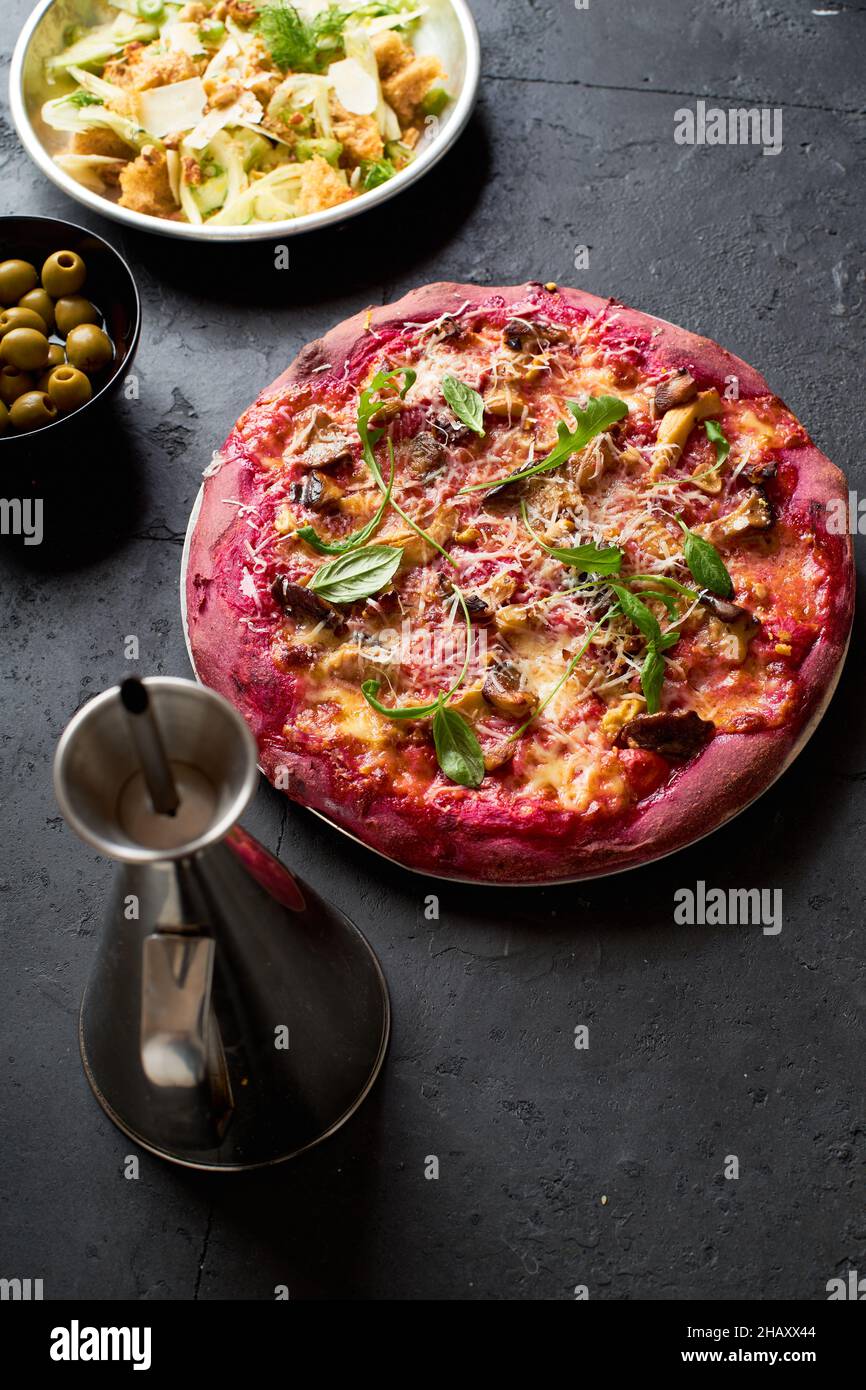 Purple colored rustic pizza with beetroot and vegetarian topping. Top ...