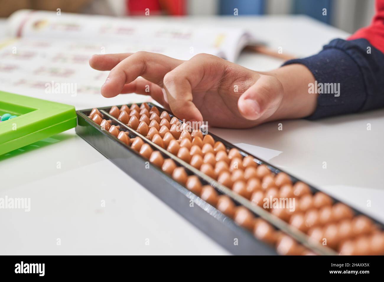 Doing mental math or mental arithmetic. Hand of little boy using abacus ...
