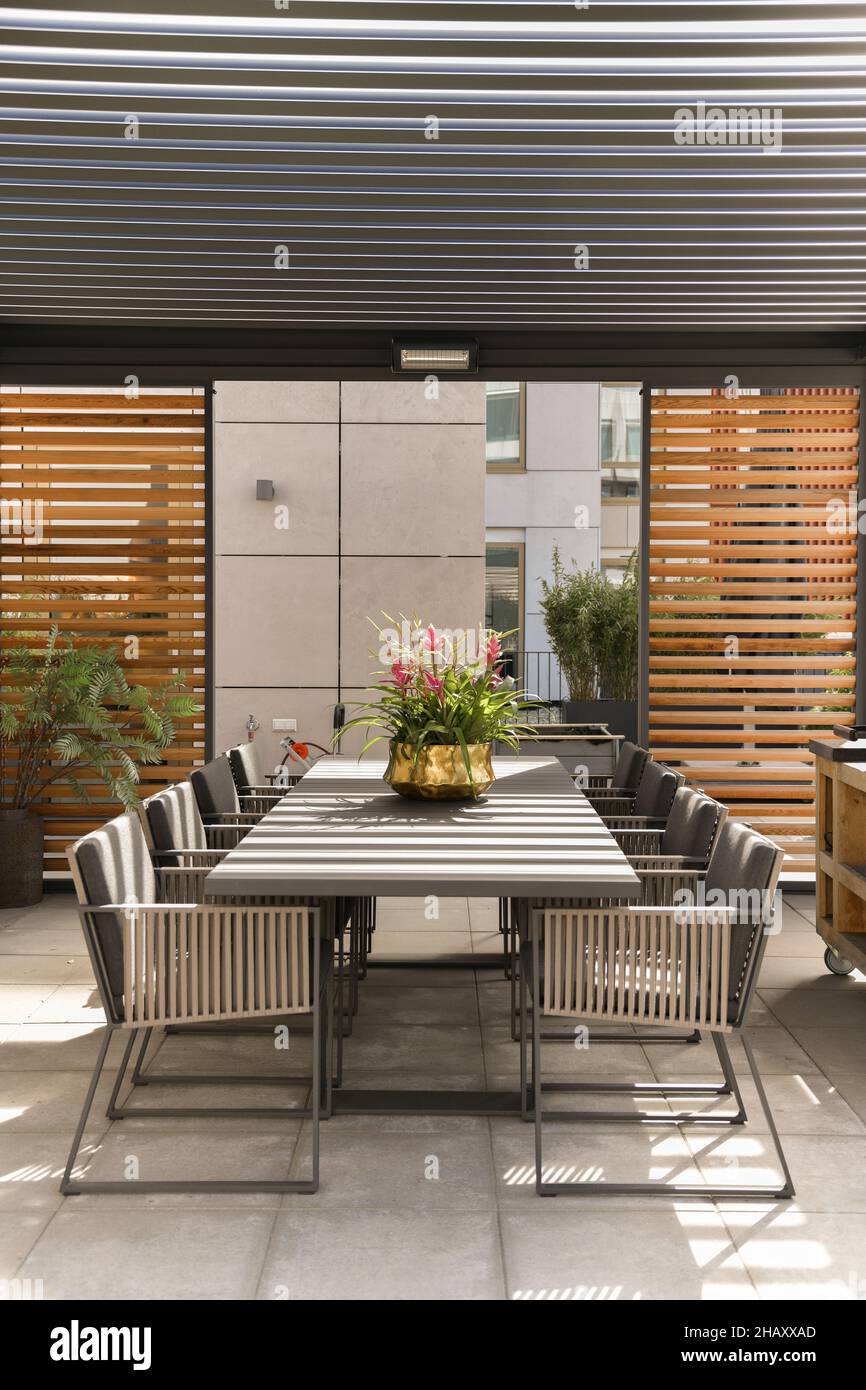 Exterior of spacious modern terrace with dining table with chairs ...