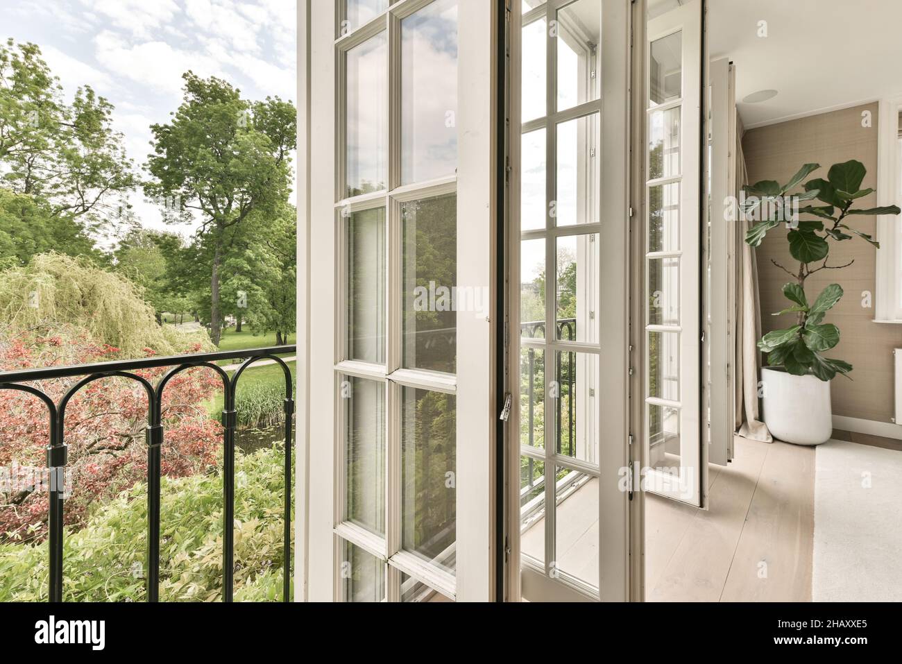 Interior of modern house with opened glass windows looking at lush ...