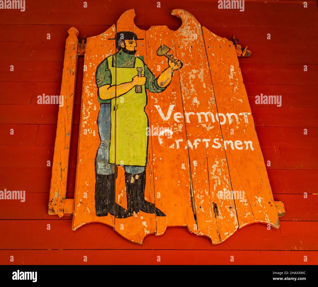 historic orange sign depicts a Vermont Craftsman in the Old Mill Museum ...