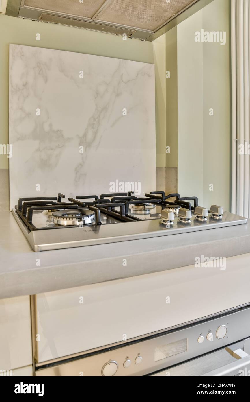 Fragment of interior of kitchen with built in gas stove with cooking ...