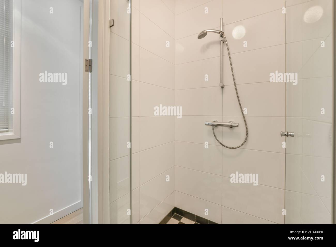 Interior of bathroom with empty shower cabin with light tiled walls in ...