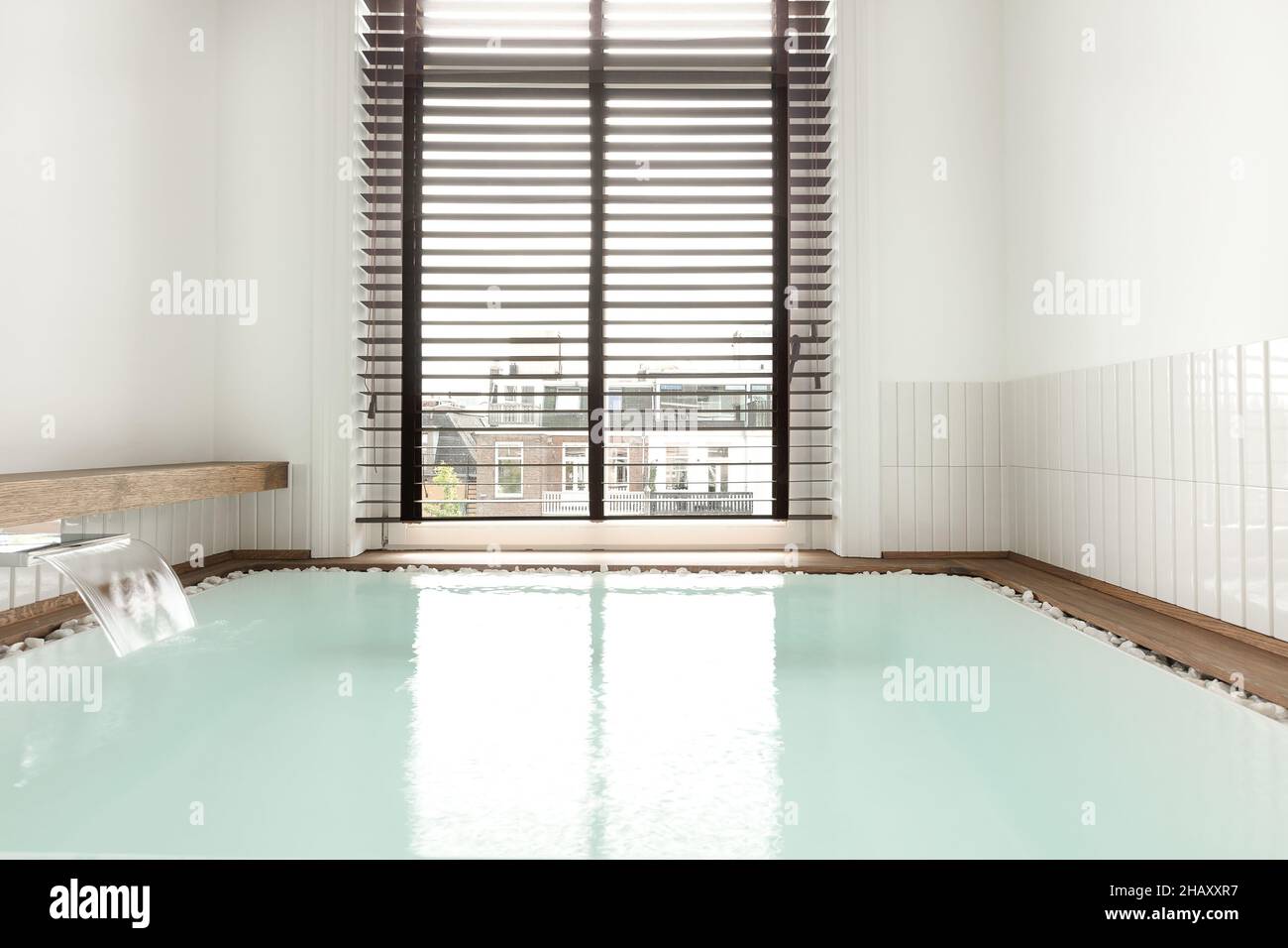 Interior of modern spacious indoors pool with waterfall jet for ...