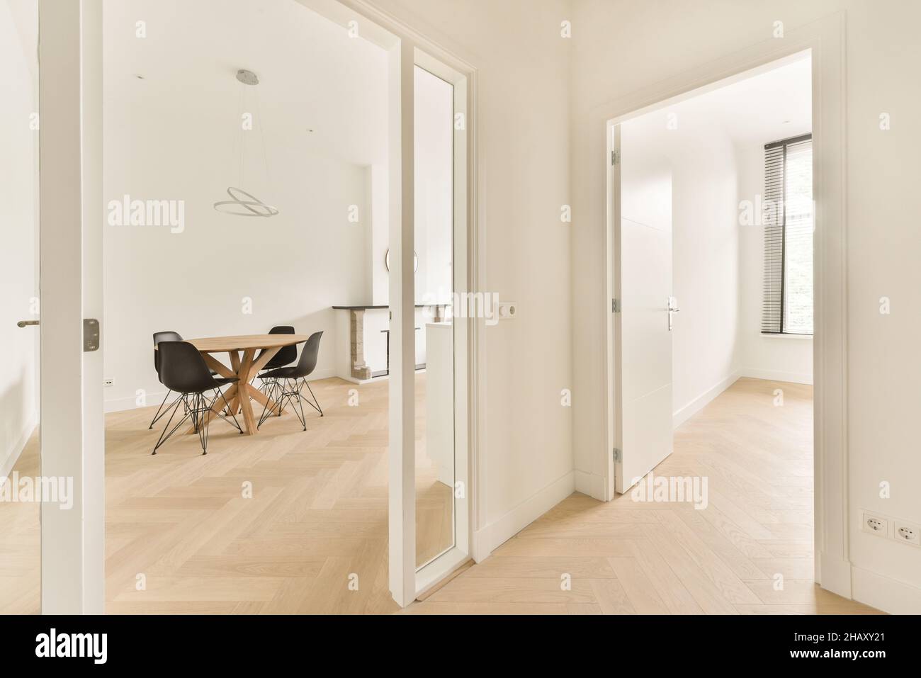 View from corridor with white walls to dining area of living room with ...