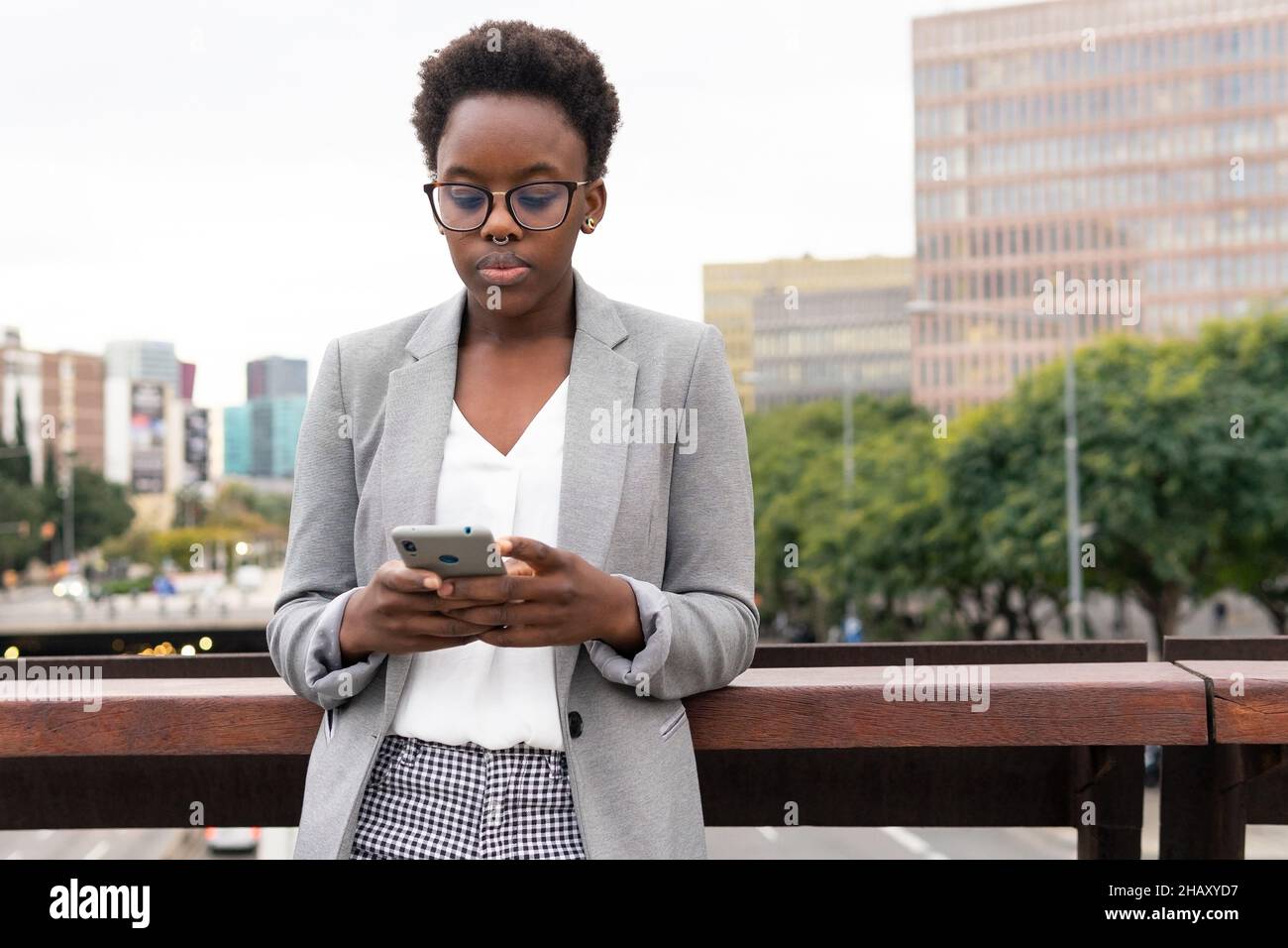 Young black female employee wearing eyeglasses and formal jacket ...