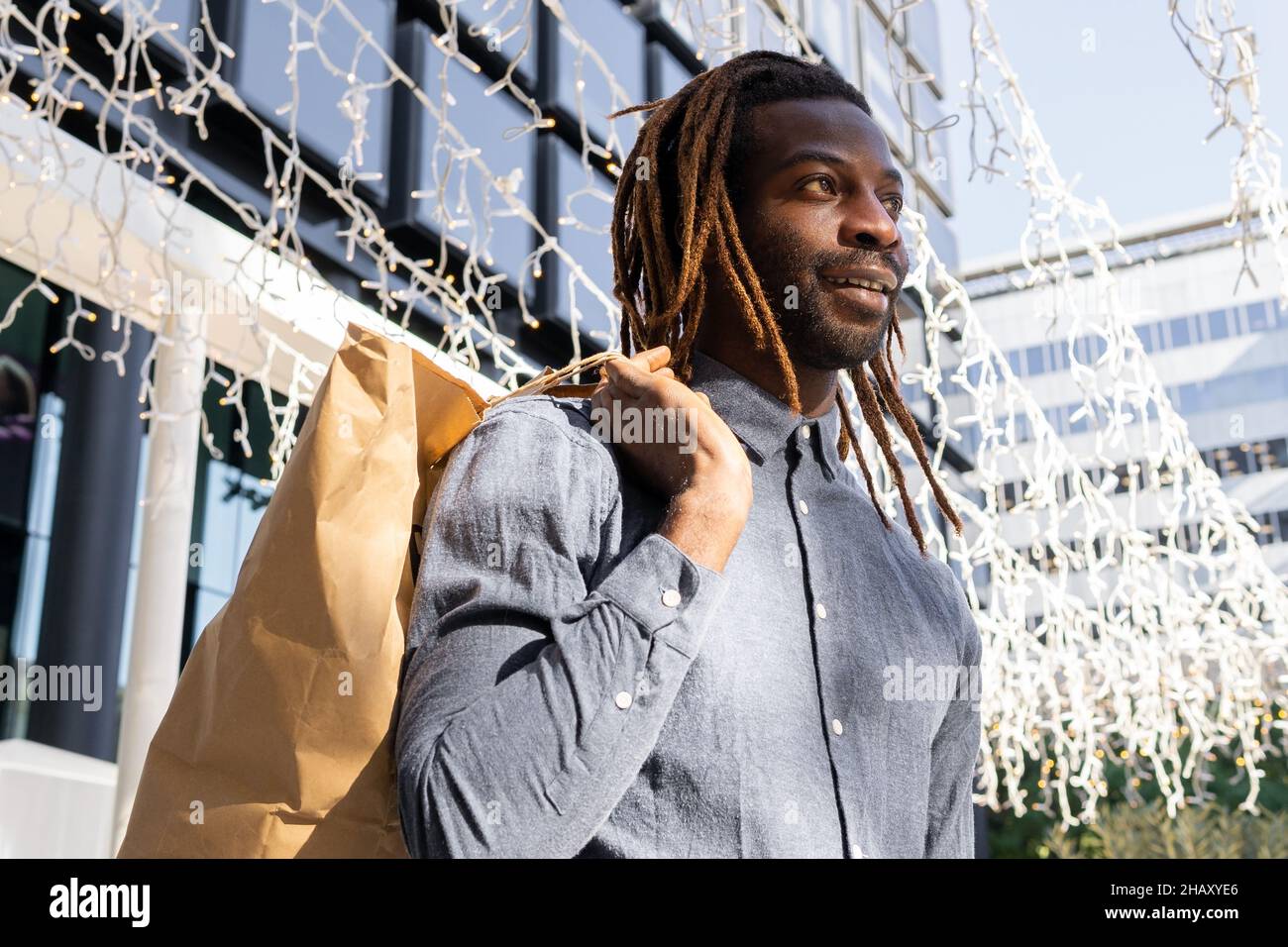 Young bearded black male with dreadlocks wearing blue shirt holding a ...