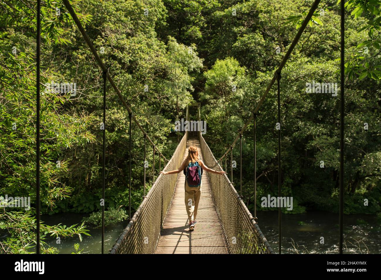 Back view of unrecognizable female tourist with backpack walking on ...