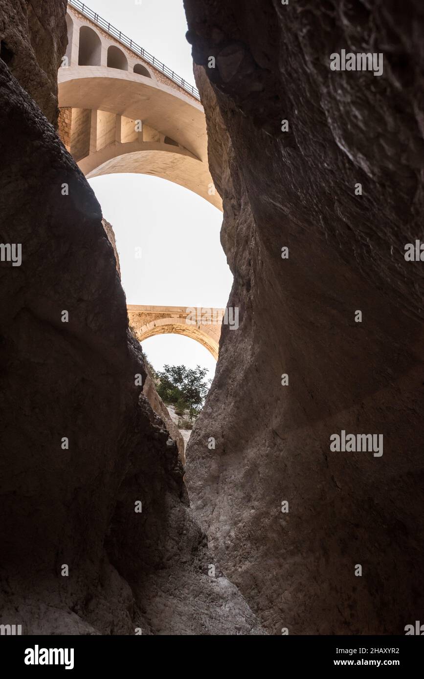 Tall stone aged bridges with arched passages located between rocky ...