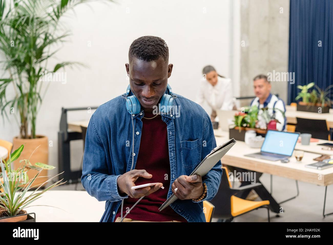 Optimistic African American male with headphones and tablet text ...