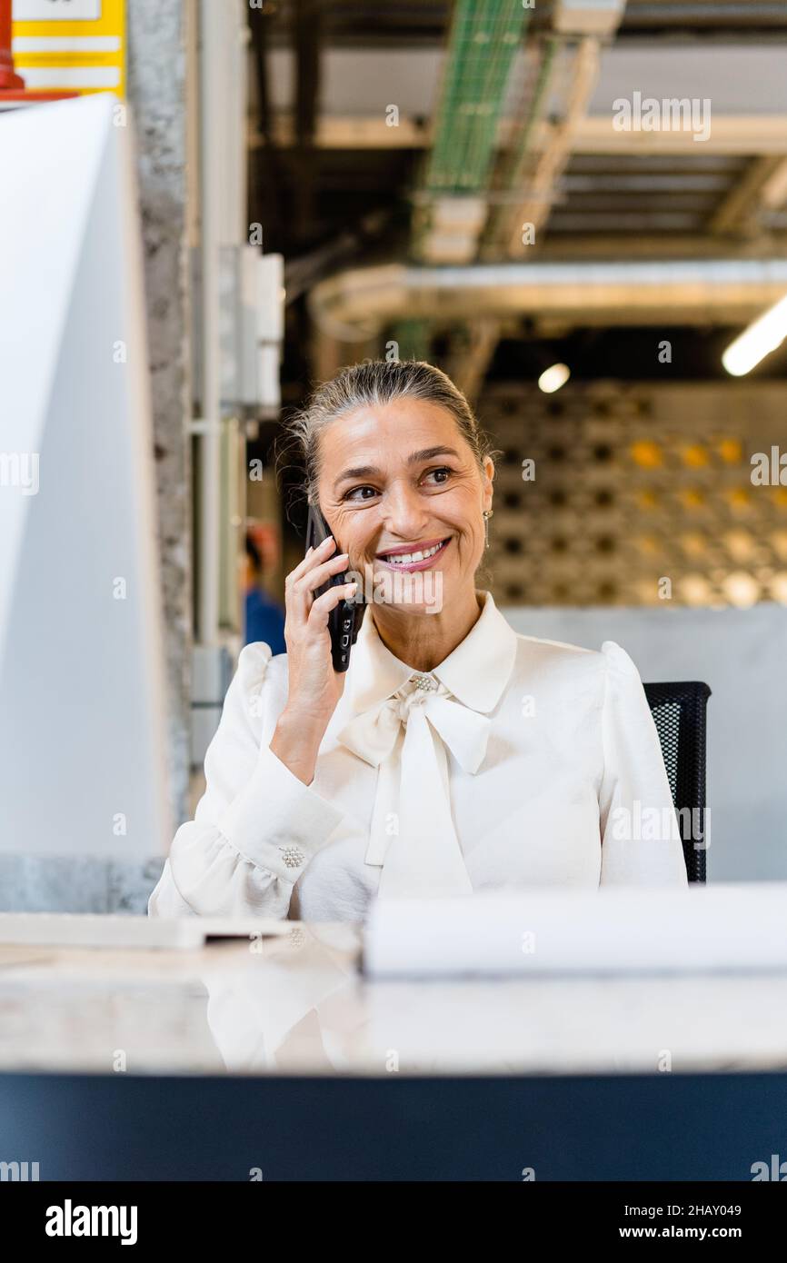 Smiling female manager in elegant outfit looking away while having ...