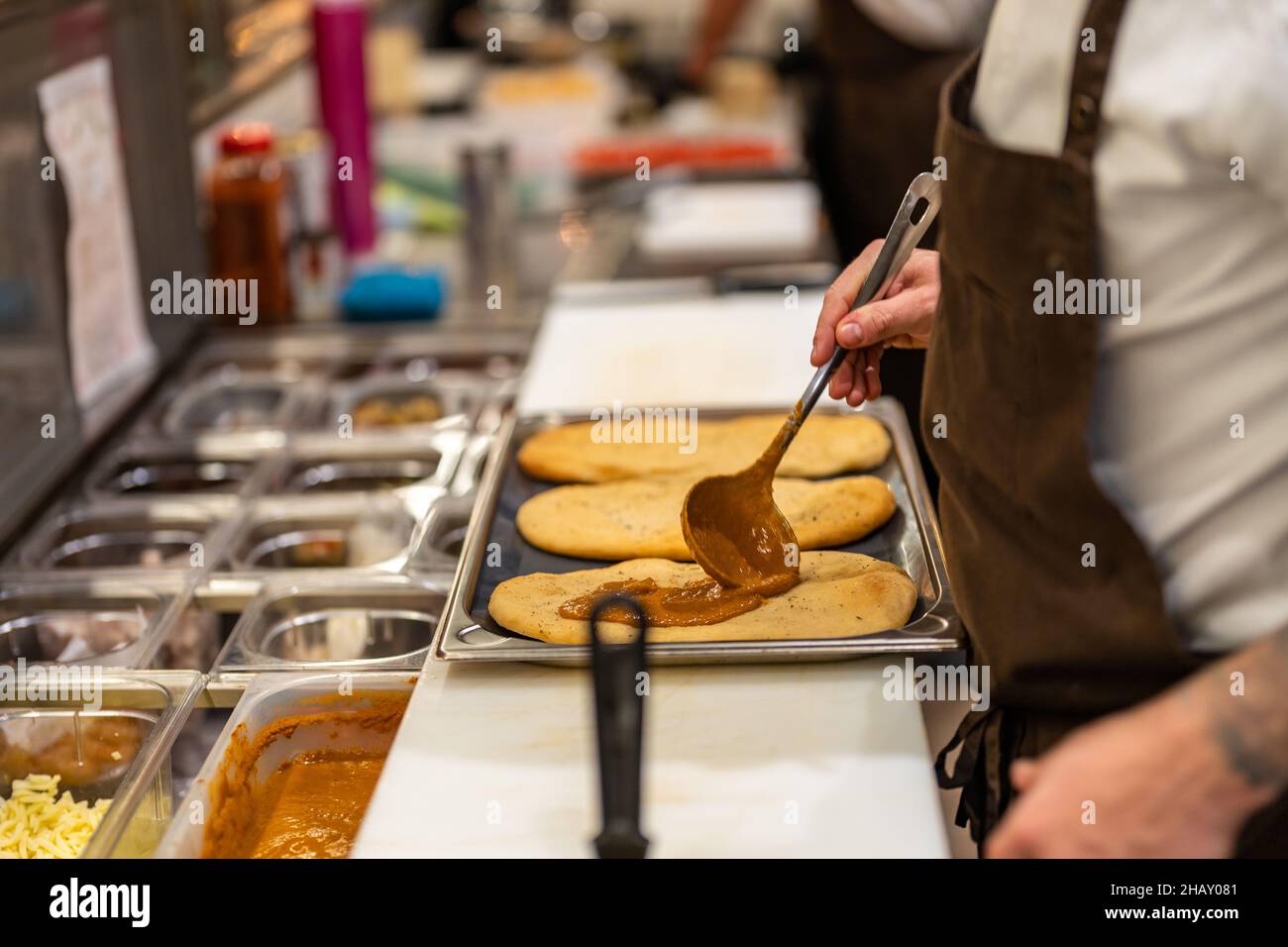 High angle side view of crop anonymous male cook with ladle spreading ...