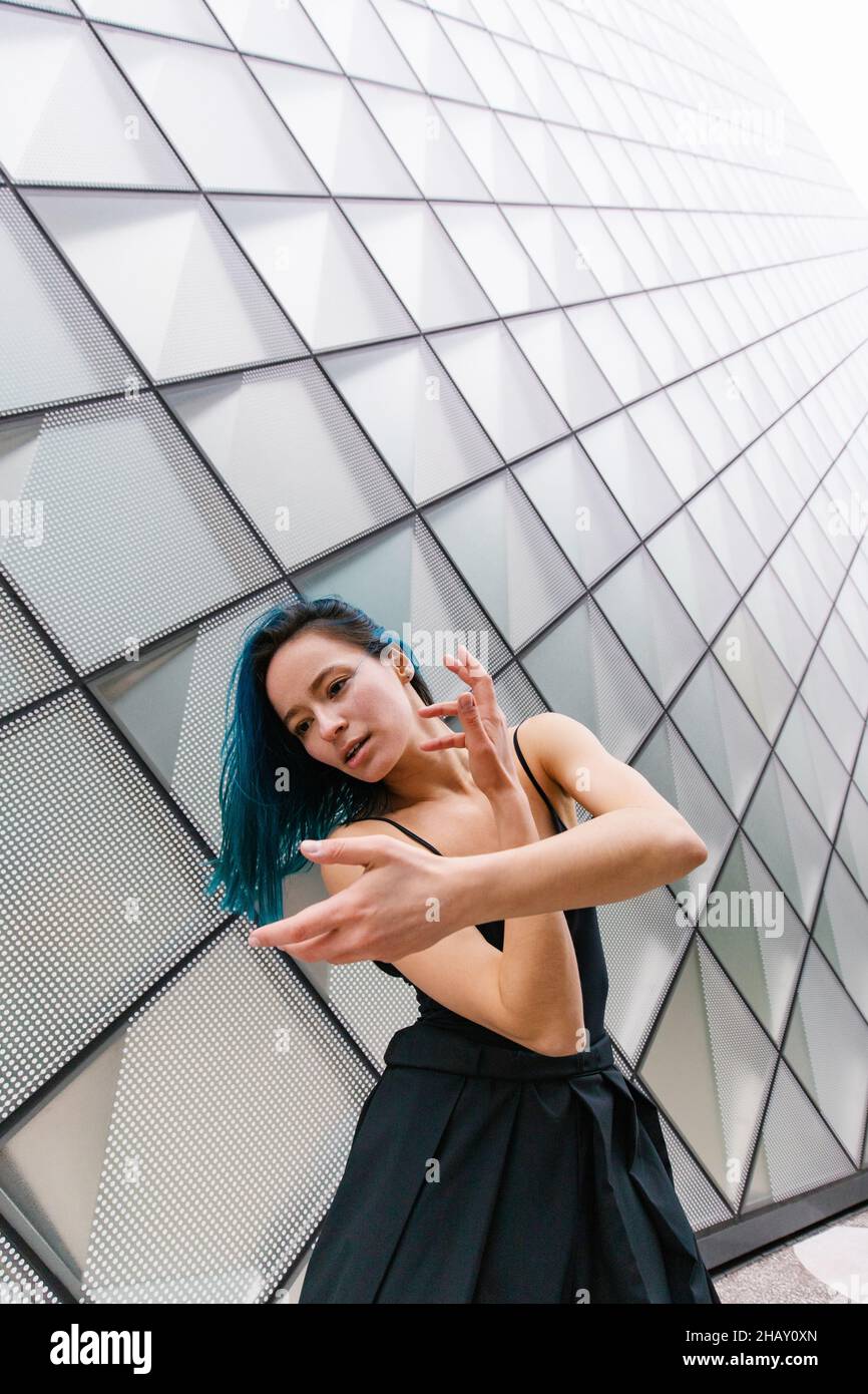 Tranquil young female model in dress sitting on floor and leaning on ...