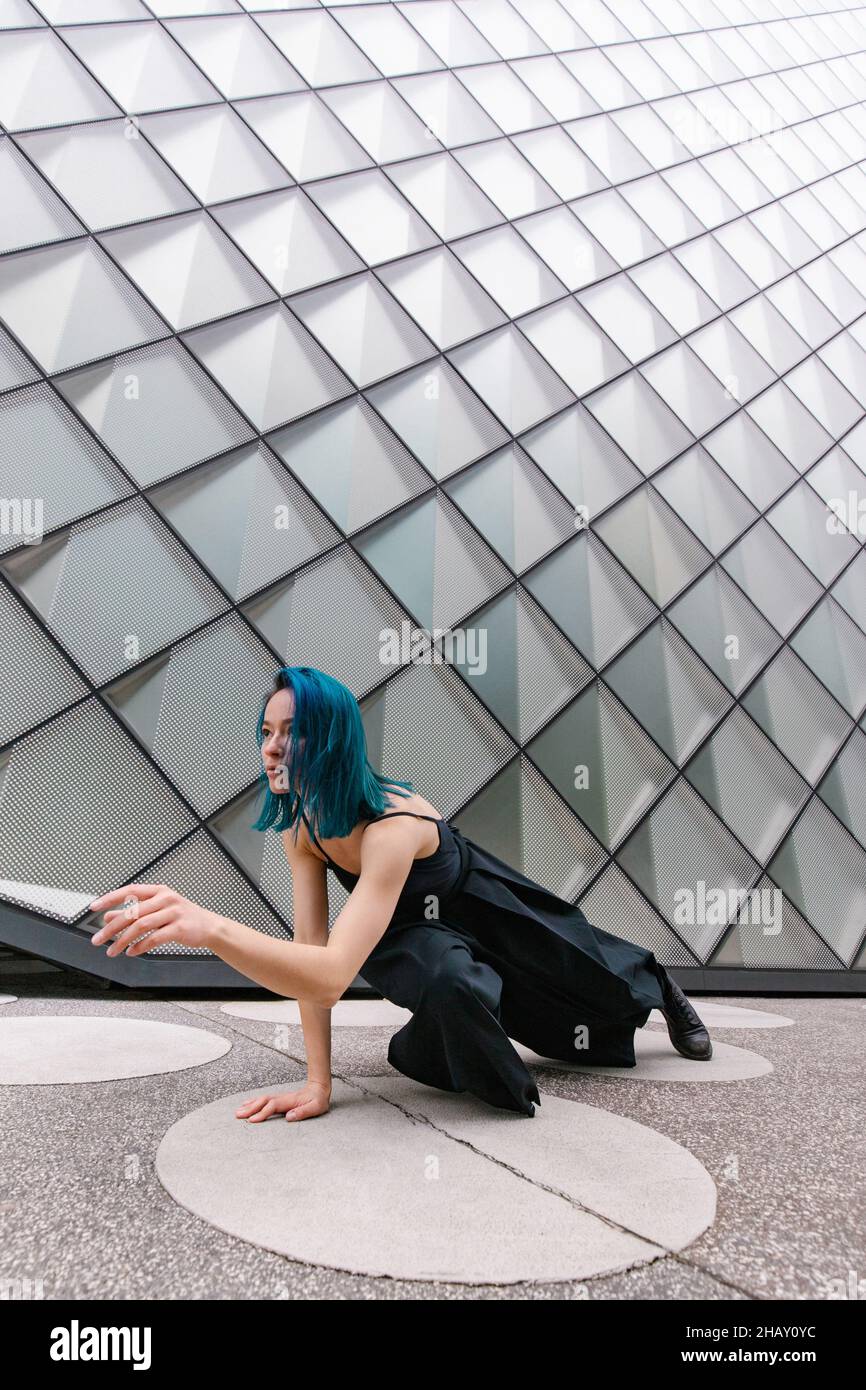 Young Woman with blue hair in black outfit performing contemporary ...