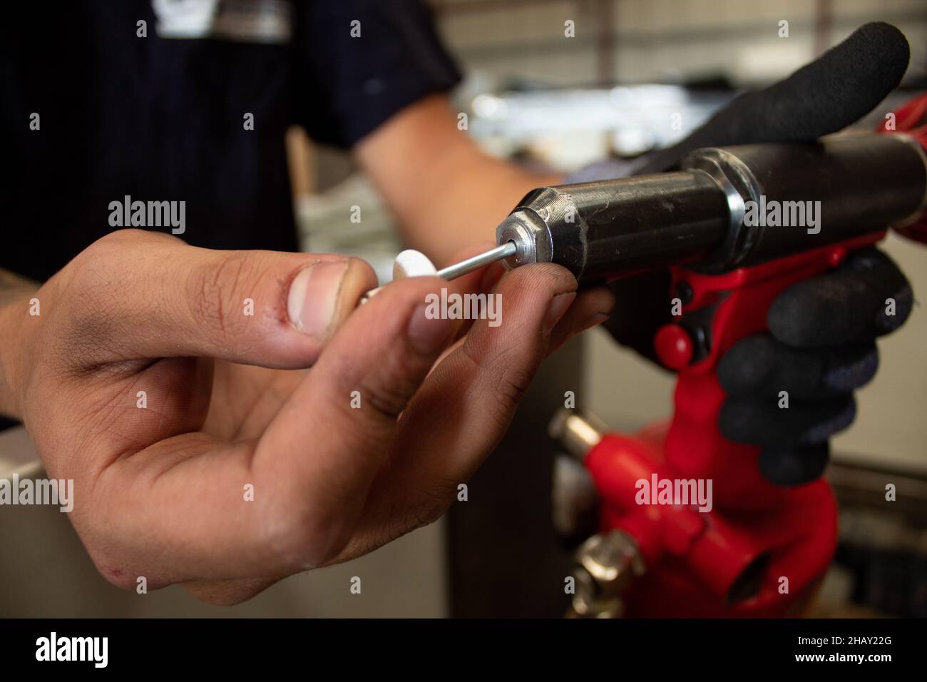 Man worker inserts a rivet into a rivet handgun Stock Photo - Alamy