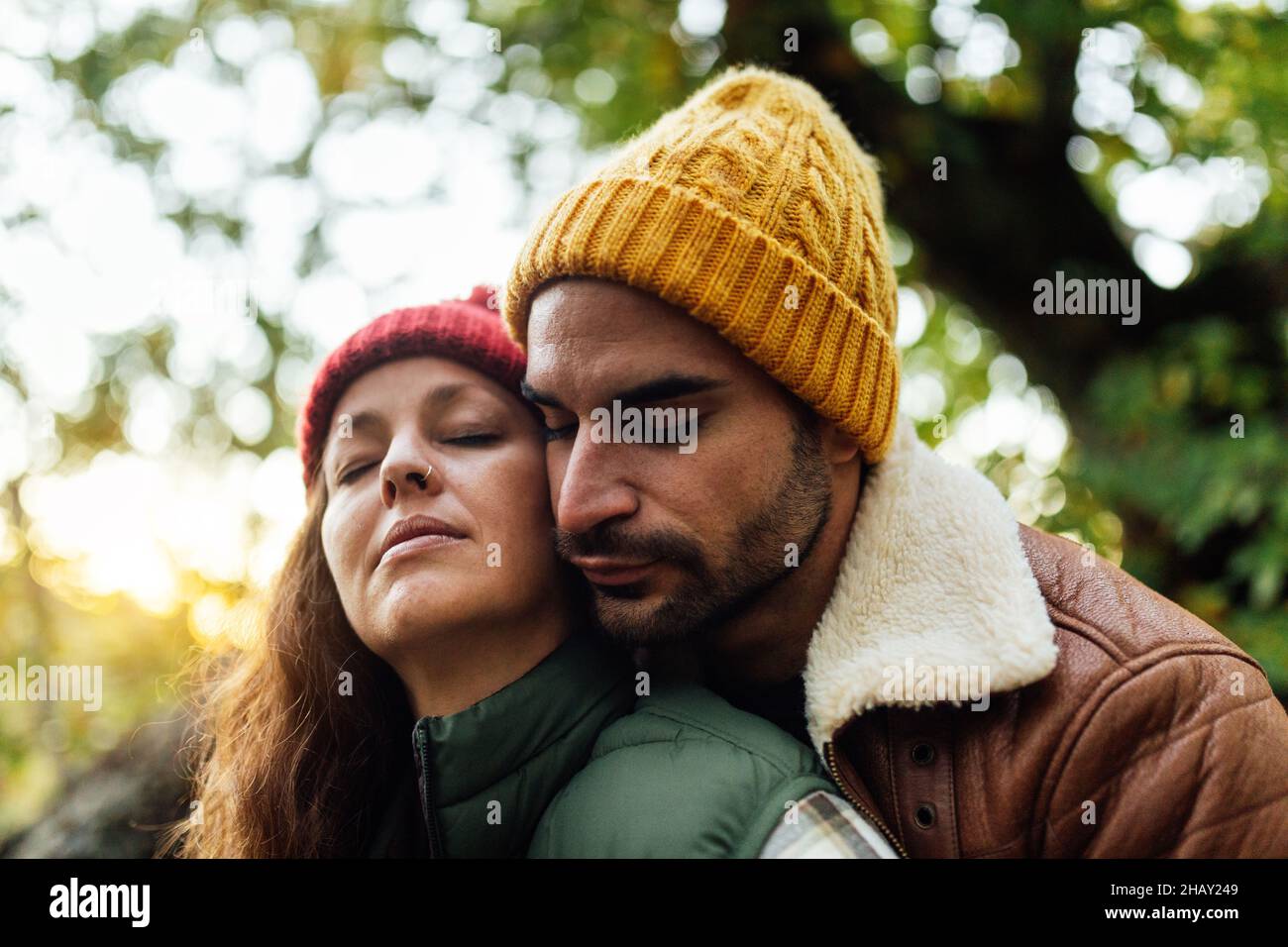 Romantic couple of tourists in warm wear embracing each other while ...