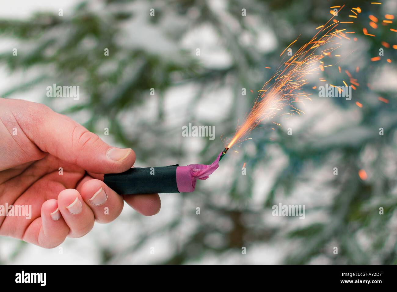 Burning Firecracker in a Hand. Guy Holding a Petard Outdoors in Winter ...