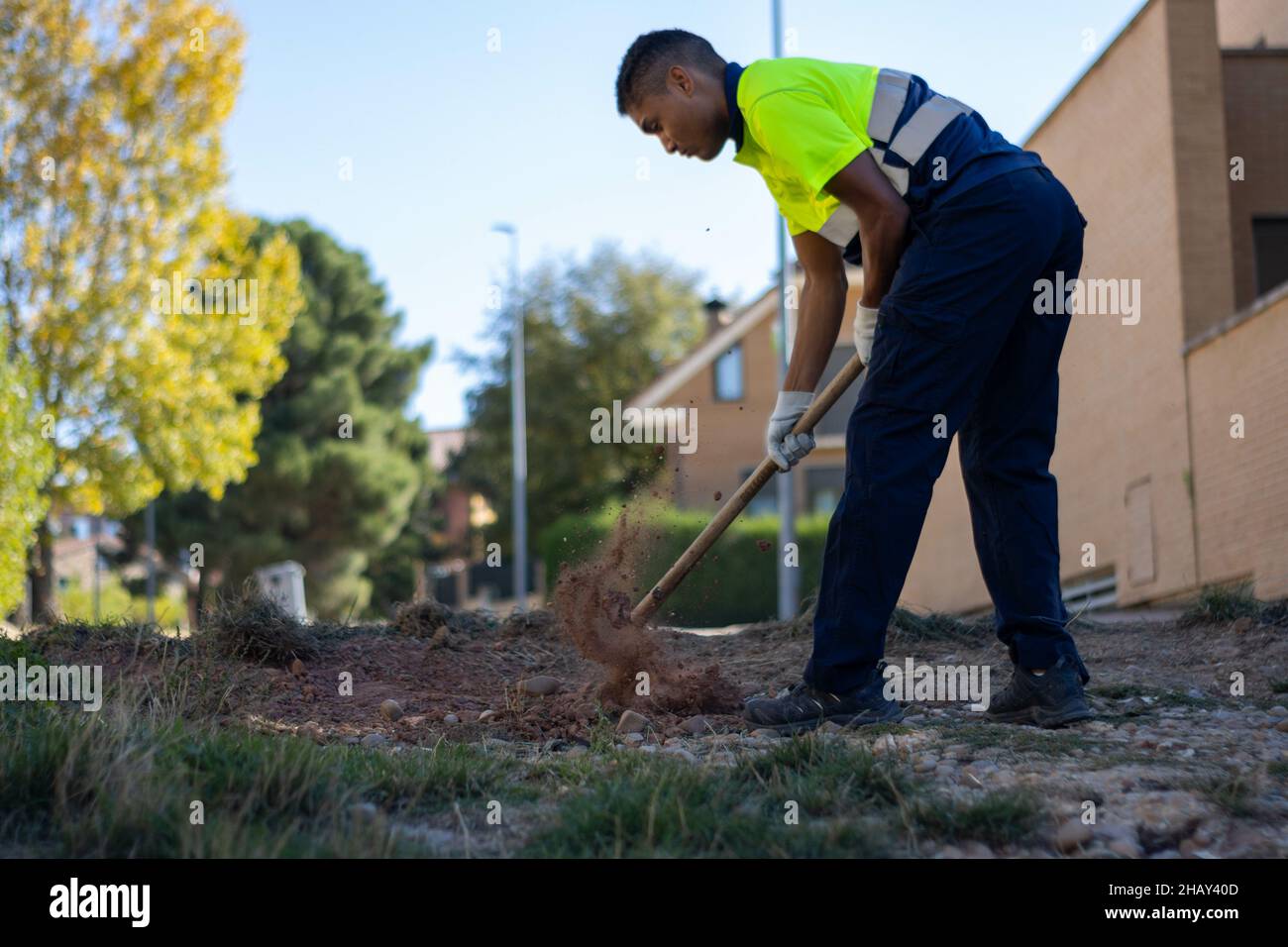 Closeup shot of a man in work clothes plowing the land with a hoe Stock ...
