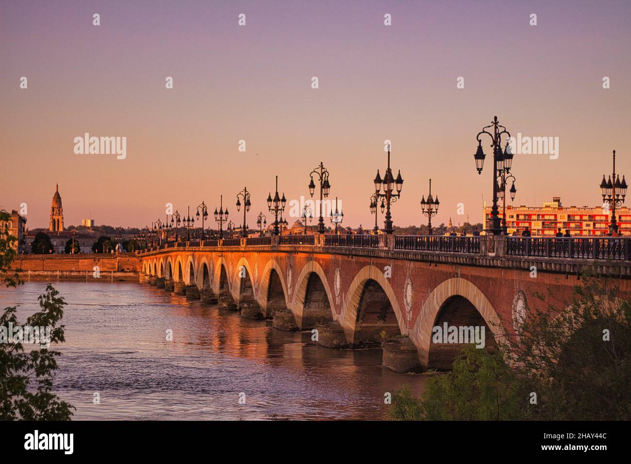 Bordeaux river bridge with St Michel cathedral during the sunset in ...
