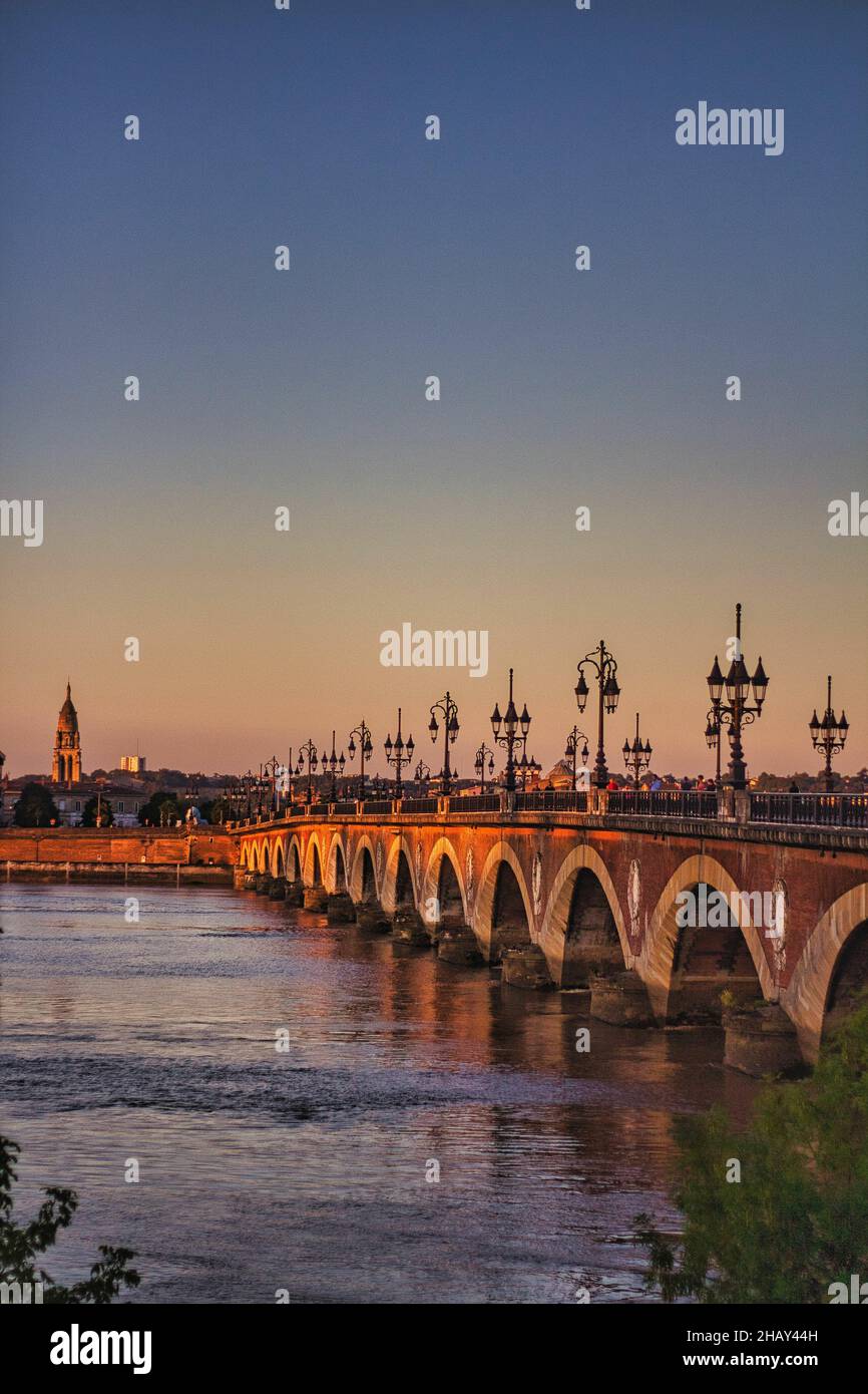 Bordeaux river bridge with St Michel cathedral during the sunset in ...