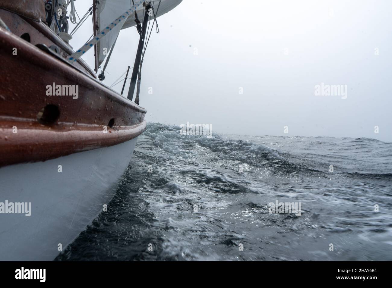 Old sailing ship in the wavy sea under a clear sky Stock Photo - Alamy