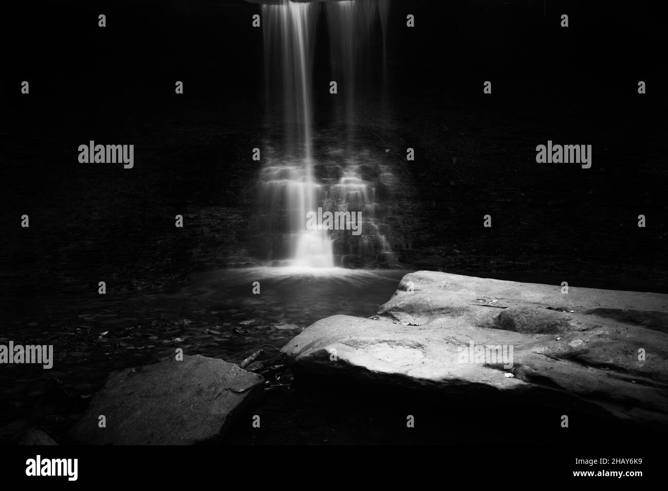 Grayscale shot of a waterfall in a cave Stock Photo - Alamy