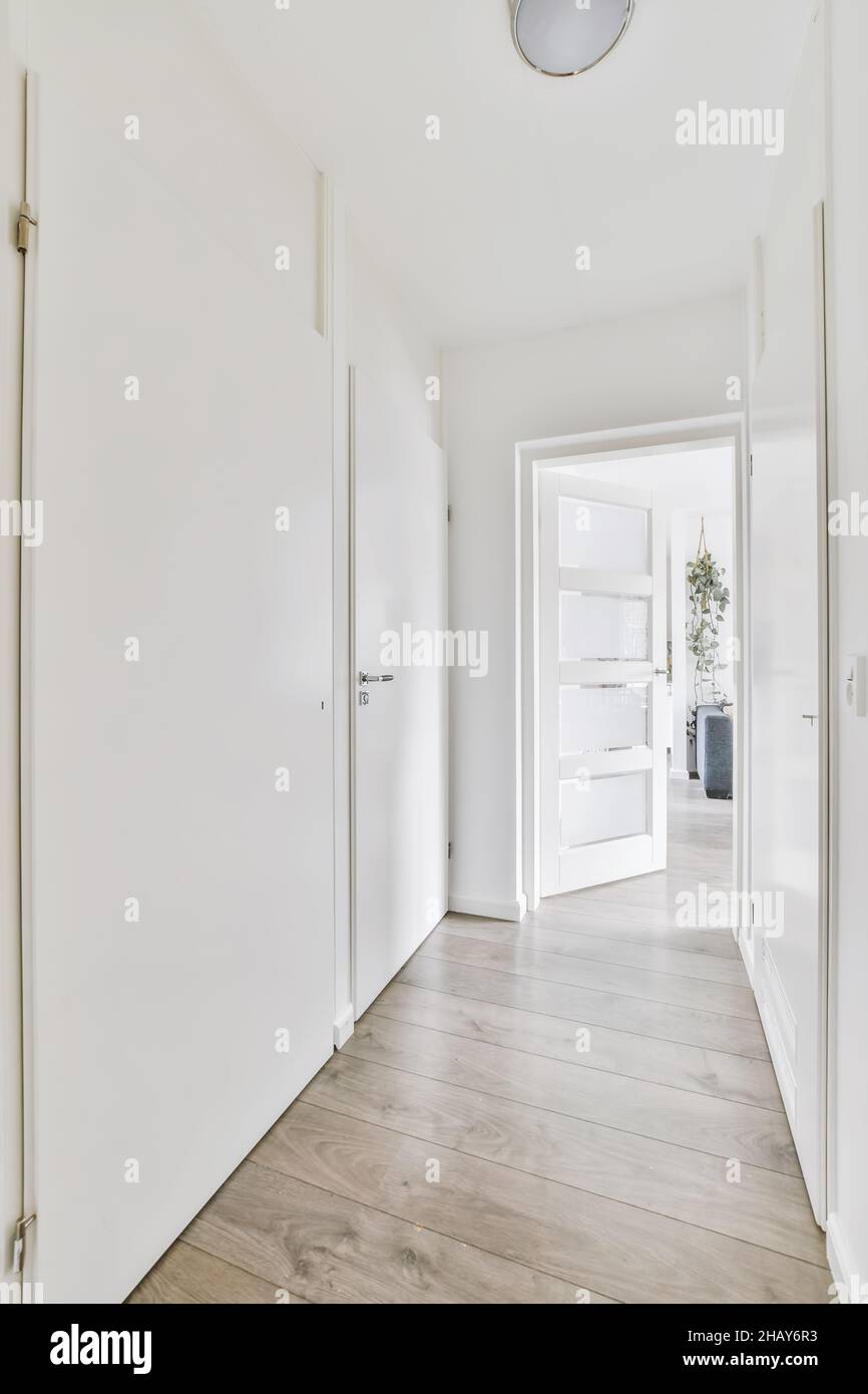 Delightful long light corridor with an open door at the end Stock Photo ...