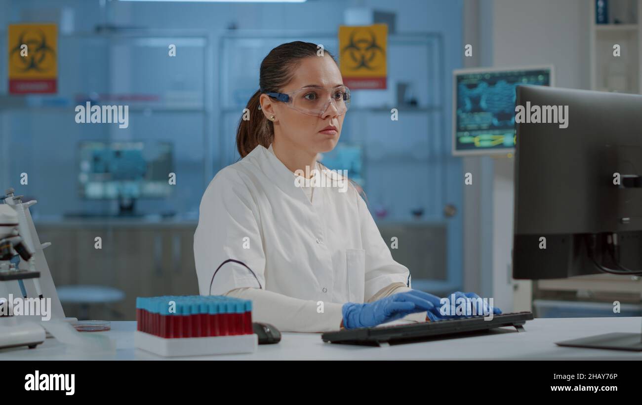 Science engineer using computer to work on chemistry experiment in ...