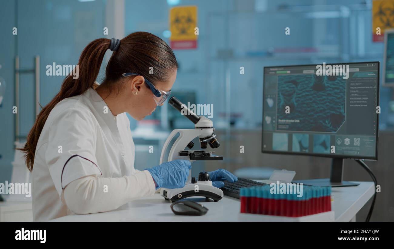 Science engineer using microscope to analyze dna sample in laboratory ...