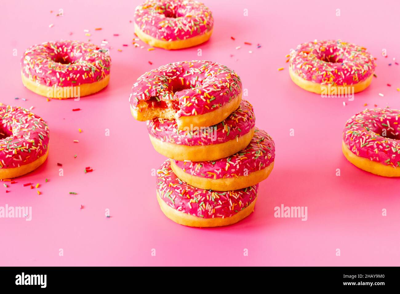 Group of pink frosted donuts with colorful sprinkles Stock Photo - Alamy