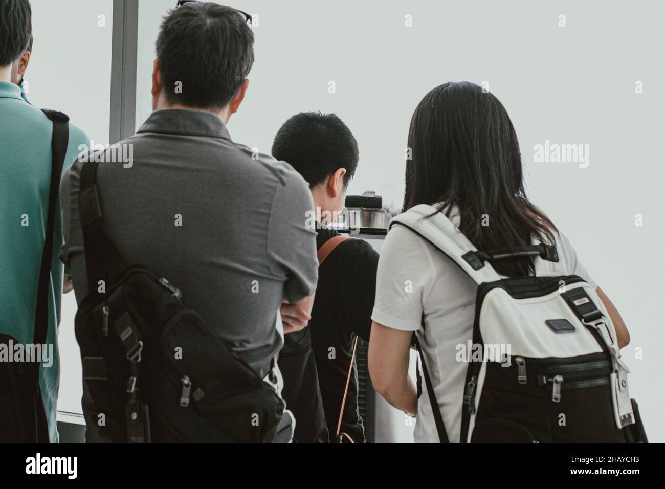 Crowd of people tourists gathering together and looking into the window ...