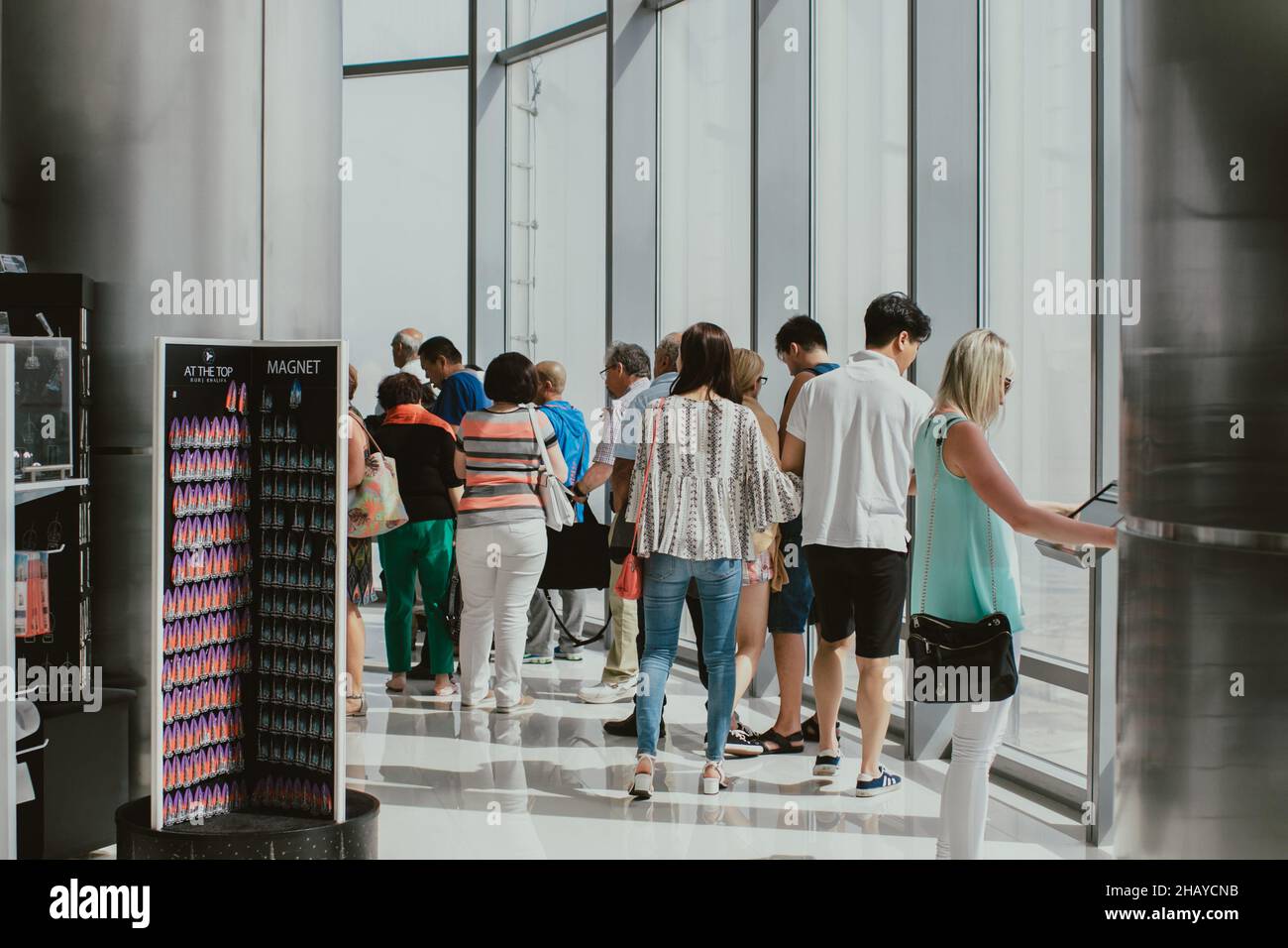 Crowd of people tourists gathering together and looking into the window ...