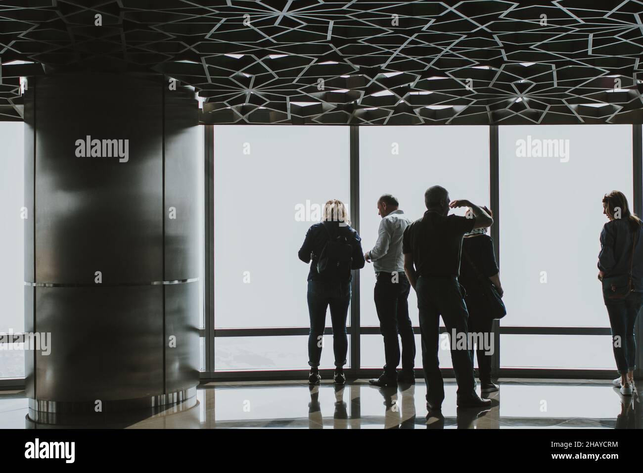 Crowd of people tourists gathering together and looking into the window ...