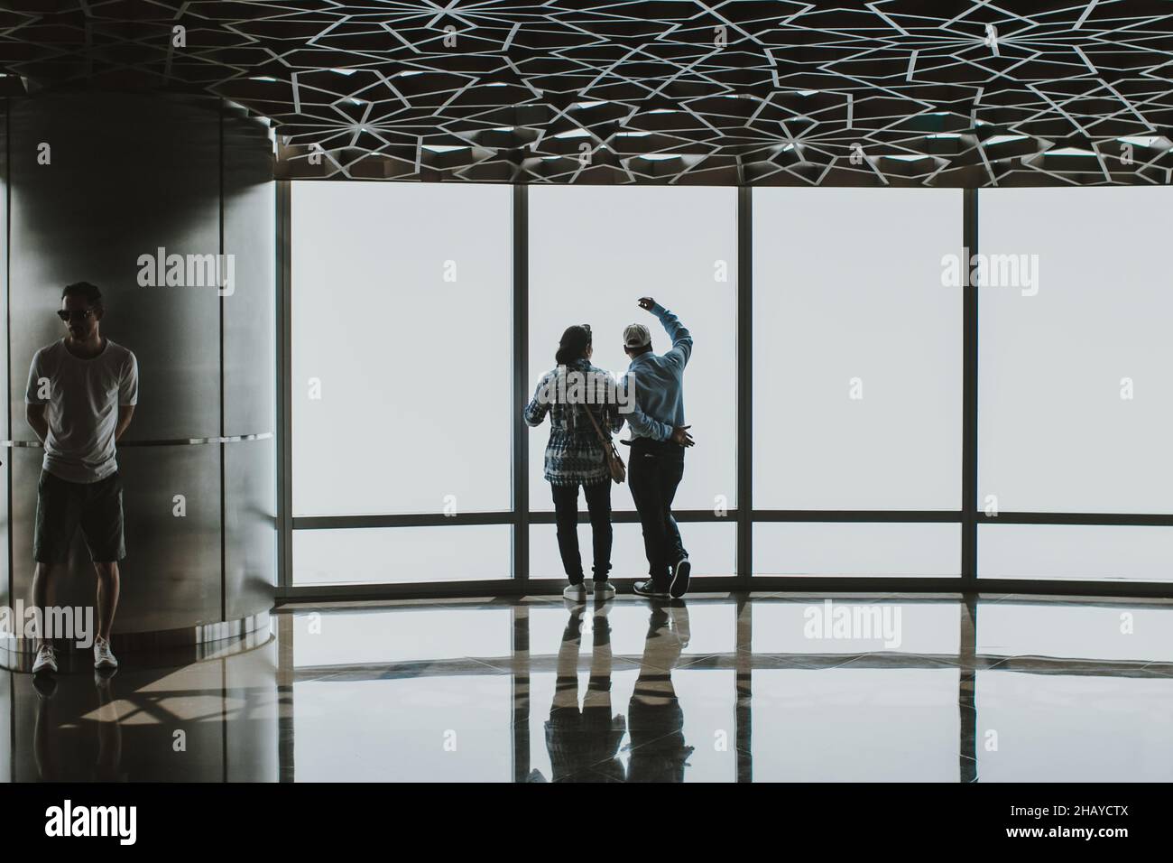 Crowd of people tourists gathering together and looking into the window ...