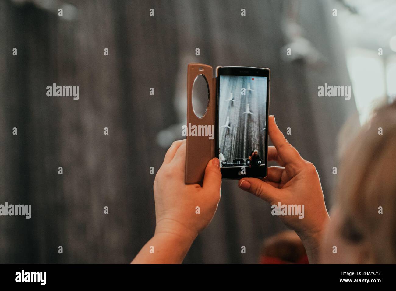 Person holding phone by taking pictures and videos on the modern ...