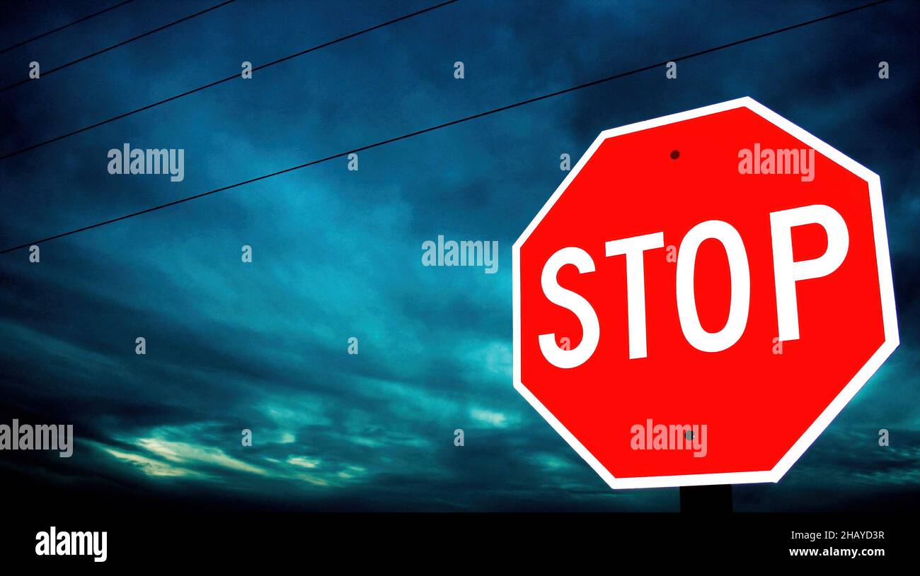Scenic shot of the Stop Sign in the twilight dark with a cloudy sky ...