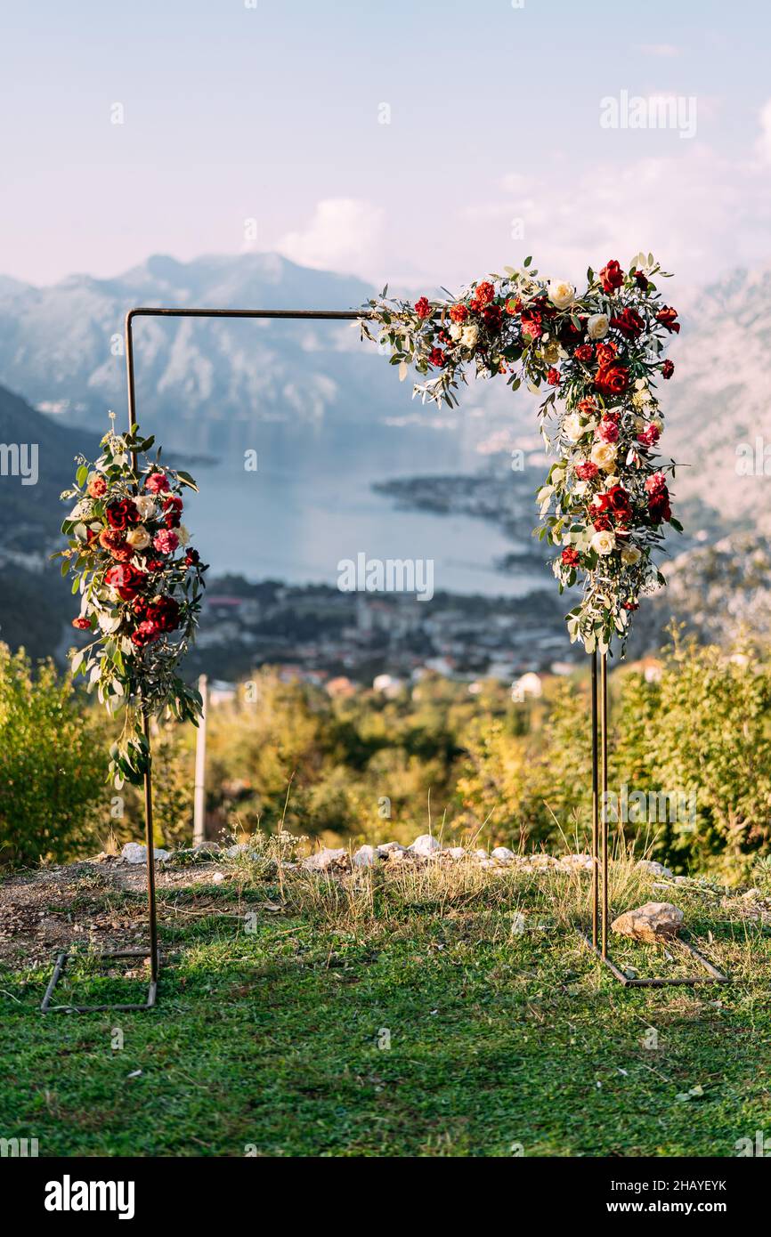 Simple rectangular metal wedding arch decorated with colorful flowers ...