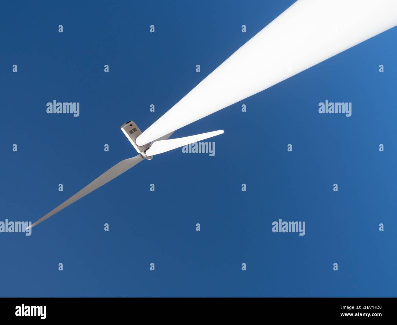 Wind turbine from below with a white column and blades against a ...