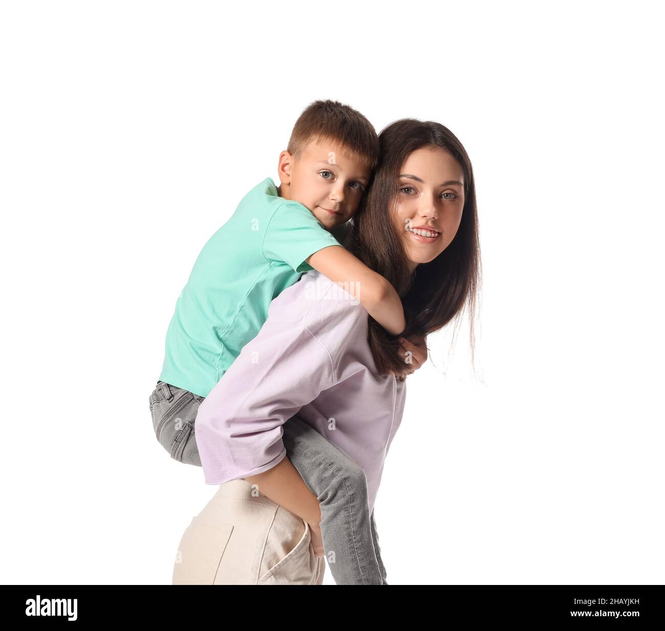 Teenage girl carrying pickaback her little brother on white background ...