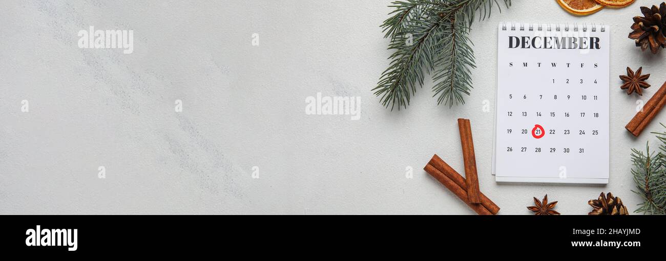 Calendar with marked date of winter solstice and decorations on white ...