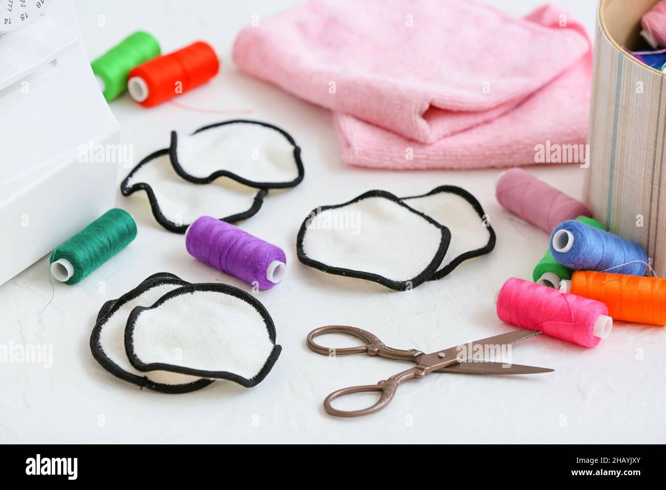 Handmade cotton pads with threads and scissors on white background ...