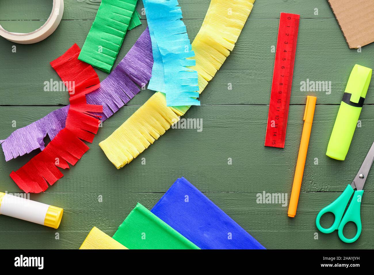 Materials for making colorful Mexican pinata on green wooden background ...